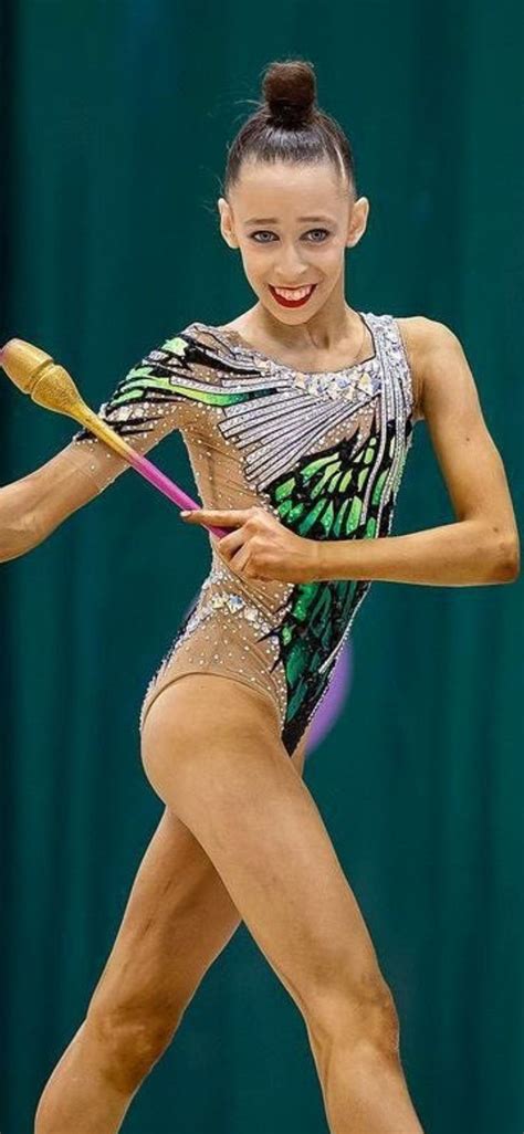 A Woman In A Leotard Is Holding A Stick