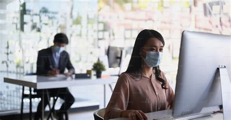 사업가나 직장인이 의료용 마스크를 쓰고 사무실에서 일하고 있습니다 사진 Unsplash의 작업 이미지