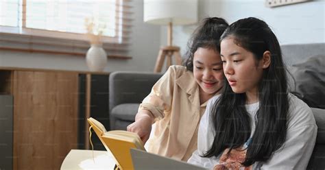 사랑스러운 아시아 소녀는 거실에서 여동생과 함께 앉아 노트북으로 인터넷을 서핑합니다 사진 Unsplash의 무선 기술 이미지