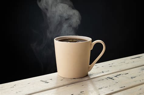 증발과 증기가있는 뜨거운 커피 한 잔과 어두운 배경에 대한 나무 테이블에 작은 물방울 0명에 대한 스톡 사진 및 기타 이미지