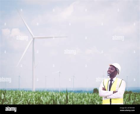 African Engineer Man Stands Holding Tablet Front The Wind Turbines