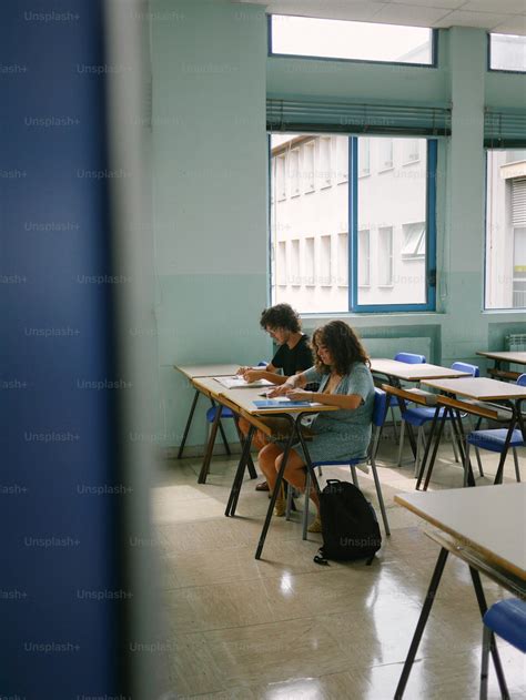 책을 펴고 책상에 앉아 있는 사람 사진 Unsplash의 숙제 이미지