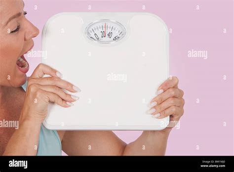 Close Up Of A Woman Holding A Bathroom Scale And Looking Excited Stock Photo Alamy