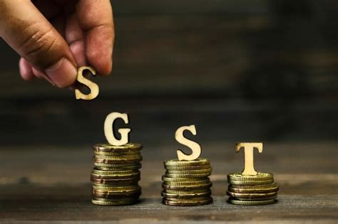 Premium Photo Cropped Hand With Gst Text On Stacked Coins At Table