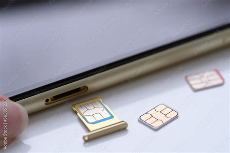 Foto De Person Inserting A Sim Card Into Back Of Mobile Phone Sim Card In Tray Being Inserted