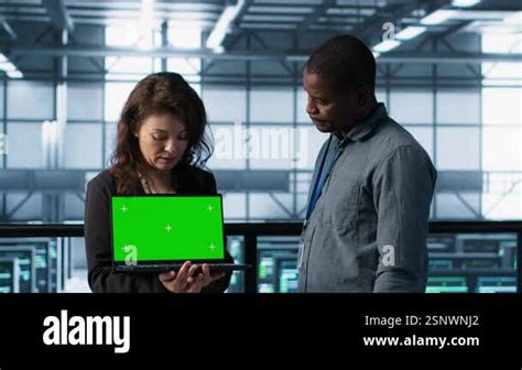 Data Center It Team Automating Routine Maintenance Tasks With Green Screen Laptop Executing