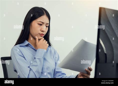 Concentrated Asian Woman Brainstorming While Coding Data On Desktop Pc