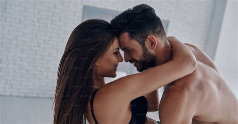 침실에 얼굴을 맞대고 앉아 포옹하고 웃는 아름다운 젊은 부부 사진 Unsplash의 창 이미지