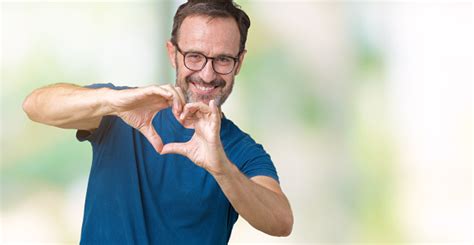 잘생긴 중 년 심장 기호와 손으로 모양을 보여주는 사랑에 웃 고 고립 된 배경 위에 안경 Wearin 노인의 수석 남자 낭만적인 개념입니다 만들기에 대한 스톡 사진 및 기타