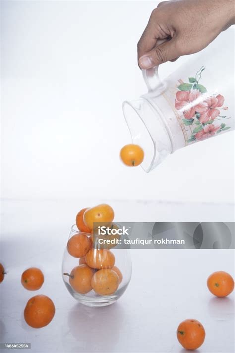 Buah Jeruk Dalam Teko Kemudian Dituangkan Ke Dalam Gelas Kaca Menuangkan Konsep Air Minum Foto