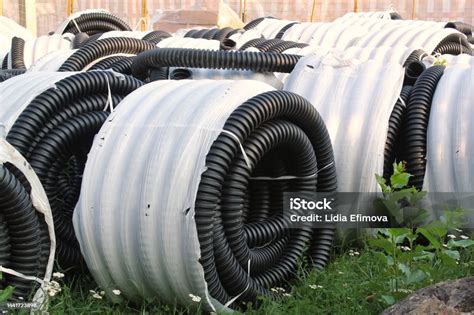 뒤틀린 고압 유연한 검은 고무 Pvc 플라스틱 호스 건축 자재 및 건물 현장의 장비 더미를 말렸다 0명에 대한 스톡 사진 및