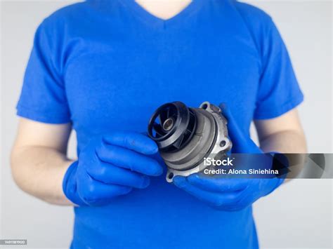 타이밍 벨트에 금이 갔습니다 고장난 엔진 변속기 벨트 교체 고무에 균열이 생기고 코드가 끊어질 위험이 있습니다 규정에 따른 장비 교체 파란 장갑을 낀 정비공 검은색에 대한