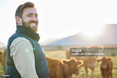 지속 가능성 소 들판에서 미소를 짓는 농부의 초상화 낙농 및 쇠고기 생산이 있는 시골의 행복한 농장 자연 육류 및 우유 농업 농업 및 식품의 지속 가능한 사업 20 24세에