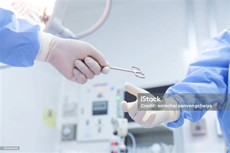아시아 외과 의사 팀이 환자를 수술하는 동안 다른 의사에게 수술 도구를 나눠줍니다 환자의 생명을 구하기 위해 의료 장비를 보유하고있는 생명을 구하는 의료 팀 수술 개념
