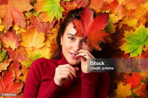 화려한 낙엽 배경 위에 손에 빨간 단풍 잎을 들고 소녀 골드 아늑한 가을 컨셉 맨 위 보기 광고를 위한 공간을 복사합니다 화창한 날 따뜻한 가을 날씨 10월에 대한 스톡