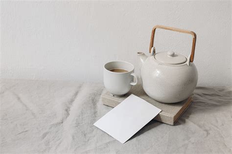 아침 식사 정물 장면 커피 한 잔 오래된 책에 차 냄비를 세라믹 빈 인사말 카드 초대 모형 베이지 색 린넨 식탁보 흰색 벽 백그루운드 중립적 인 아침 라이프 스타일 구성