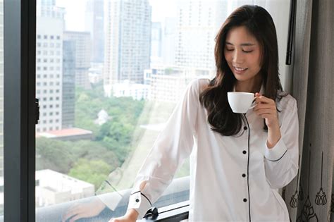 침실의 창문 근처에 서있는 아침에 일출을 바라보는 매력적인 여성 아침에 차 나 커피 한 잔을 들고 아름 다운 여성 30 34세에 대한 스톡 사진 및 기타 이미지 Istock