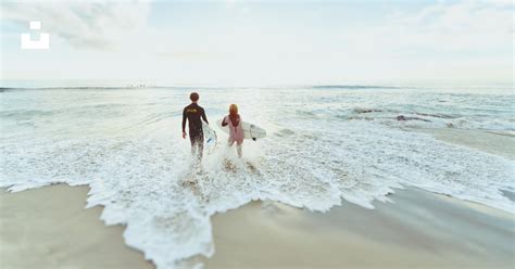 권운과 푸른 잔잔한 하늘 아래 서핑 보드를 들고 해변에 있는 남자와 여자의 솔직한 사진 사진 Unsplash의 무료 바닷가 이미지