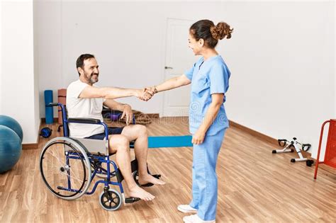 Middle Age Man And Woman Smiling Confident Having Physiotherapy Session