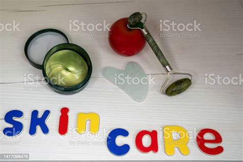 스킨 케어 액세서리 Gua Sha 롤러 뷰티 도구 크림 아이 패치 옆의 옥 롤러 및 편지로 만든 단어 스킨 케어 뷰티 살롱 개념