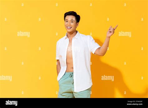 Summer Portrait Of Smiling Handsome Asian Man Pointing Finger Up In