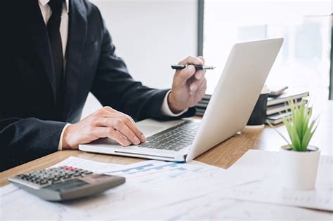 보고서 문서 및 분석을 사용 하 여 랩톱 컴퓨터에서 새 프로젝트를 작업 하는 사업가 그래프 문서에 대 한 재무 데이터 계산 재무