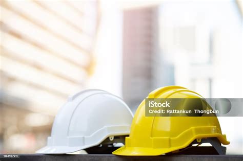 노란색과 흰색 하드 안전 착용 헬멧 모자 건설 현장 건물에서 콘크리트 바닥에 햇빛 엔지니어 또는 노동자로 노동자 헬멧 개념 안전을 최우선으로 합니다 0명에 대한 스톡 사진