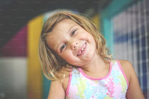 遊び場の小さな女の子。カメラを見ている白人の女の子。の写真 Unsplashの子供時代の画像