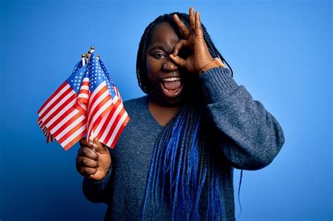 젊은 애국 아프리카 계 미국인 플러스 크기의 여자 와 머리띠 들고 미국 국기 와 행복한 얼굴 웃고 있는 확인 사인 을 하고 손에