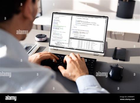 Computer Programmer Writing Program Code On Computer In Office Stock