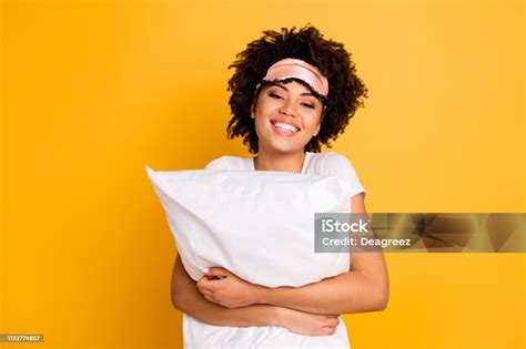 클로즈업 사진 아름 다운 놀라운 그녀 그녀의 어두운 피부 레이디 손 포옹 포옹 베개 큰 주말 각 성 착용 수 면 마스크 캐주얼 화이트 티셔츠 고립 된 노란색 밝은 활기찬