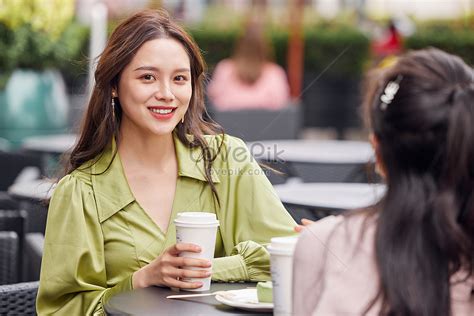 Young Girlfriends Are Drinking Drinks In Front Of Outdoor Table Picture