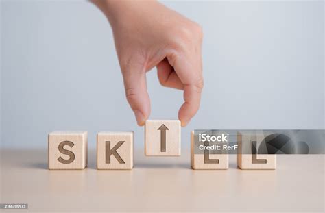 나무 큐브에 Skill 단어가 있는 위쪽 화살표 아이콘을 손으로 선택합니다 업스킬링 및 개인 개발 개념 업스킬 훈련 지식 및