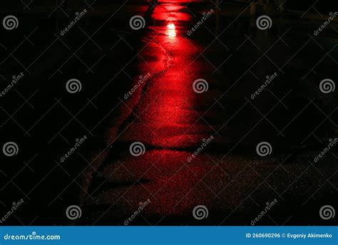 Reflection Of A Red Traffic Light On The Pavement Editorial Photo