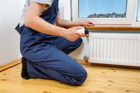 Premium Photo Repair Heating Radiator Closeup Man Repairing Radiator With Wrench Removing Air