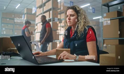 female logistics specialist scans parcel with barcode scanner checks