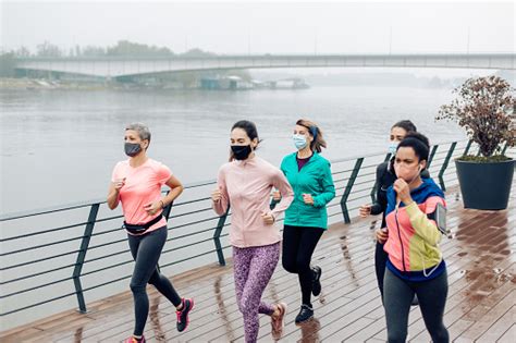 젖은 추운 날에 얼굴 마스크를 쓰고 조깅을 하는 여성 그룹 25 29세에 대한 스톡 사진 및 기타 이미지 25 29세 35