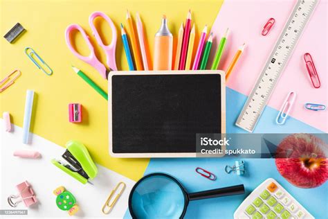 교육 또는 학교 개념으로 돌아갑니다 파스텔 종이 배경에 책 컬러 연필 계산기 펜 커터 클립과 사과 다채로운 학교 용품의 상단보기