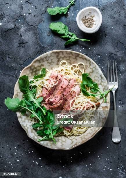 후추 스테이크 파스타 어두운 배경에 얇게 썬 쇠고기 스테이크와 로켓 샐러드를 곁들인 스파게티 파스타 탑 뷰 건강한 식생활에 대한 스톡 사진 및 기타 이미지 Istock