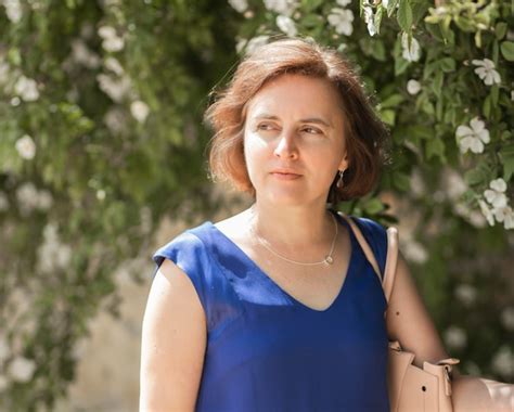 Premium Photo 48 Year Old Woman In A Blue Dress Near A Blooming White