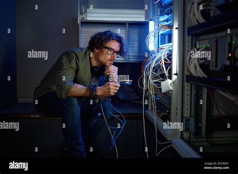 Male Network Engineer Connecting Cables In Server Room Stock Photo Alamy