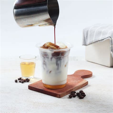 Barista Prepares A Refreshing Cold Coffee Drink With Ice And Milk