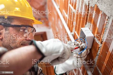 건설 현장의 전기 시스템에서 일하는 전기 기술자 건설 산업 55 59세에 대한 스톡 사진 및 기타 이미지 55 59세