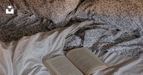펼쳐진 책이 지저분한 침대 위에 놓여 있다 사진 Unsplash의 무료 책 이미지