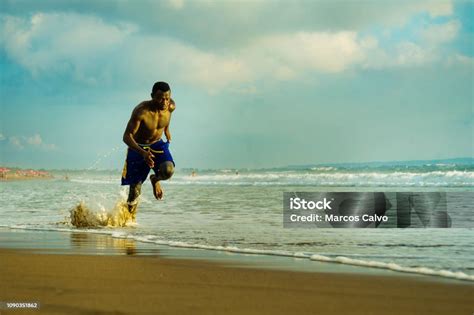 매력적인 젊은 운동과 강한 아프리카계 미국인 흑인 비치 훈련 열심히 하 고 역주에서 프로 선수 생활에서 바다 물에 실행 하 고