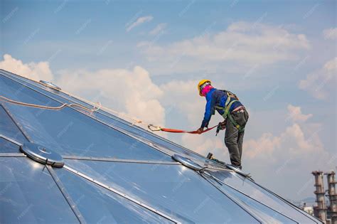 남성 근로자 로프 접근 높이 안전 매듭 안전 장치 지붕 추락 방지 및 추락 방지 앵커 포인트 시스템과 연결되어 오름차순 건설 현장 오일 탱크 돔 프리미엄 사진