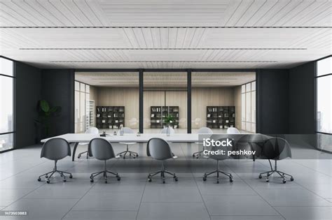 밝은 천장 콘크리트 바닥 및 유리 벽 배경이 있는 넓은 회의실의 콘크리트 바닥에 휠체어로 둘러싸인 거대한 흰색 회의 테이블의 전면 보기 3d 렌더링 3차원 형태에 대한 스톡