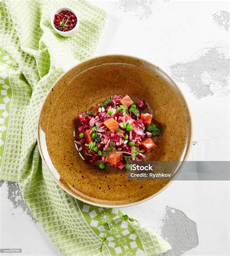 전통 러시아 샐러드 삶은 야채 양배추와 녹색 Pease에서 비네그레트 소박한 스타일로 연어와 비네그레트 샐러드 돌 배경에 그릇에 채식 요리 러시아어 음식 감자 요리에 대한