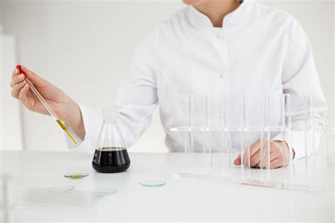 시계 유리에 마리화나 공장에서 추출한 Cbd 오일을 테스트 안경을 가진 여성 과학자 그녀는 실험을 위해 유리 드롭퍼와 그릇을 사용 하 고 있습니다 의료 대마초에서 의료 약국