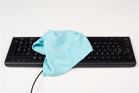 Premium Photo Cleaning Computer Keyboard In Office With A Rag Cloth